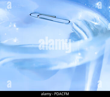 Surface tension of water. Paper clip floats on water in the laboratory ...