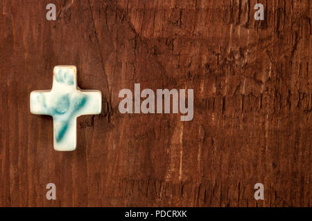 An overhead photo of a simple cross, teal and white, with a little ...