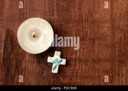 An overhead photo of a simple cross, teal and white, shot from above on ...