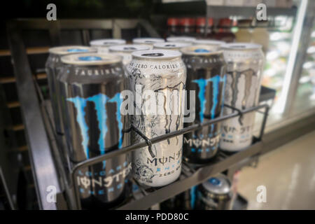 A display of Monster energy drinks cans on the shelves of a grocery ...