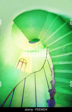 Steps up to a circular lighthouse with yellow flowers in the foreground ...