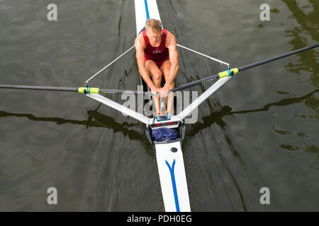 A single scull boat and rower on the water, view from above. Motion ...