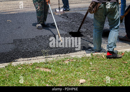 Road street repairing works. Construction workers during asphalting ...