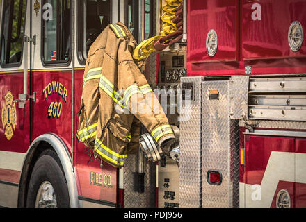 Firefighter coat hanging on fire truck Stock Photo - Alamy