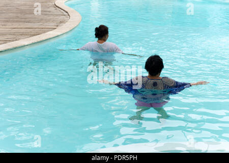 Two senior women doing aqua gym exercise in outdoor swimming pool Stock ...
