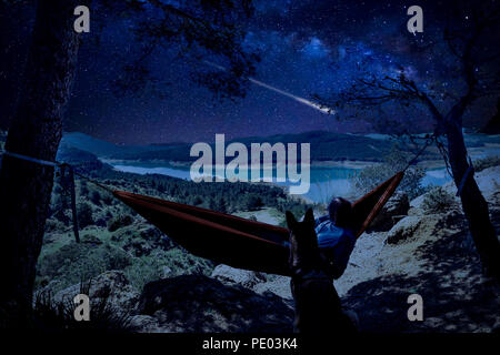 Man with dog observe Perseid Meteor Shower and the Milky Way outdoor ...