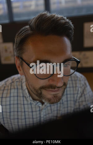 Smiling man in formals working on laptop inside office Stock Photo - Alamy