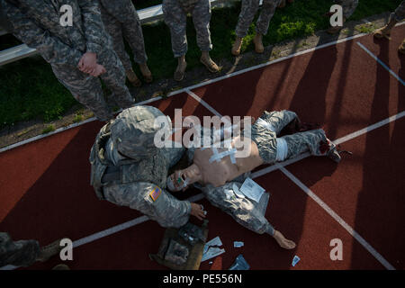 Using a medical mannequin, an Army combat medic teaches an Airman to ...