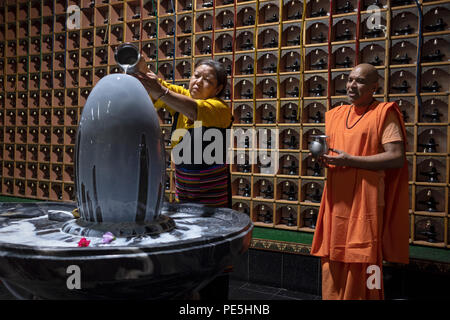 Hindu woman pouring milk over a Shiva lingam. Neelkanth Mahadev Temple ...
