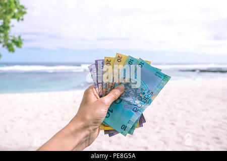 Samoan Tala currency (WST) - left hand holding colorful bank notes from ...