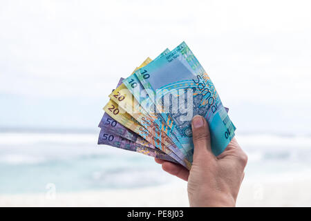 Samoan Tala currency (WST) - right hand holding colorful bank notes ...