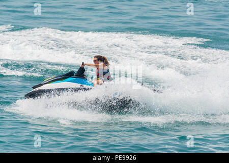 Woman riding a jet ski on the sea in Summer in the UK. Water sports.Jet ...