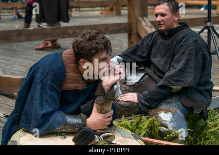 Medieval tired warrior knight in chain mail armour sits and rests among ...
