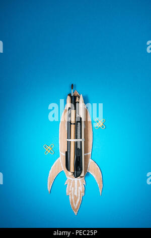 Paper rocket with school stationery on light background Stock Photo - Alamy