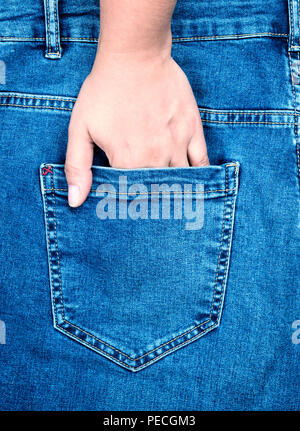 female hand is stuck in the back pocket of blue jeans, close up, full ...