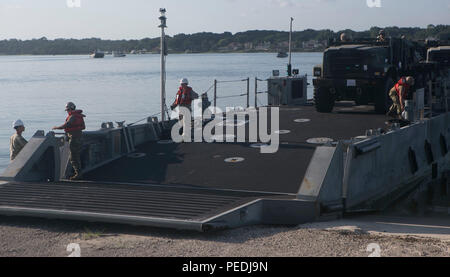 Sailors unload equipment from an Improved Navy Lighterage System (INLS ...