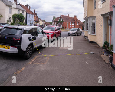 electric car charging with a cable across the pavement Stock Photo - Alamy