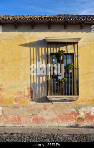 Window of an old colonial house with grills and white curtain inside ...