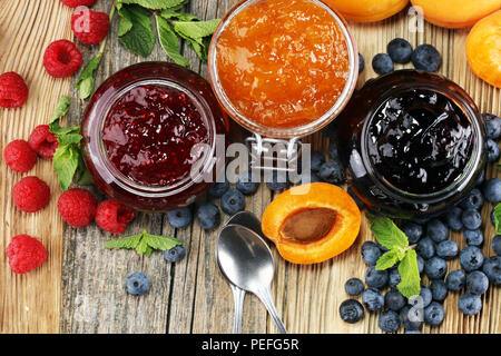 assortment of jams, seasonal berries, apricot, mint and fruits ...