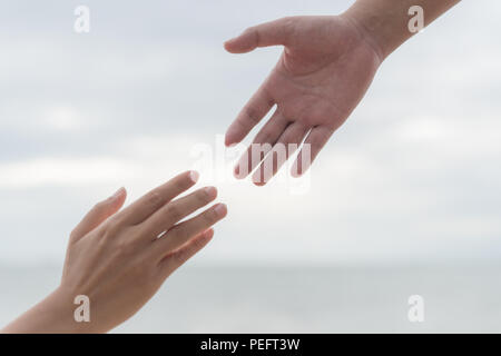 helping hands on blurred sea and sky background. Friendship Day concept Stock Photo - Alamy