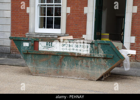 A skip full of rubble and building waste on a private construction site ...