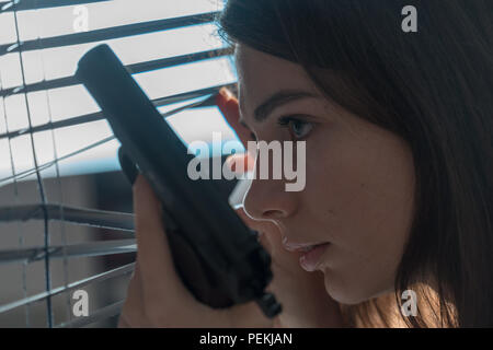 young woman with a gun at the window Stock Photo - Alamy