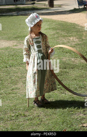 Little child playing hoop and stick in Colonial Williamsburg, Virginia ...