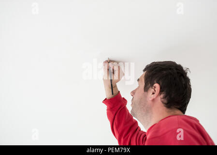 workman or builder marking ceiling with pencil Stock Photo - Alamy