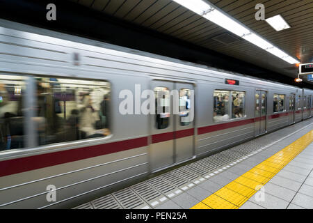 Tokyo Metro yellow subway train arriving to a subway station platform ...