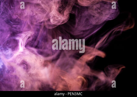 Thick colorful blue and purple smoke on a black isolated background ...