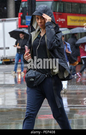A woman uses an umbrella to shield from rain in The Loop as a storm ...