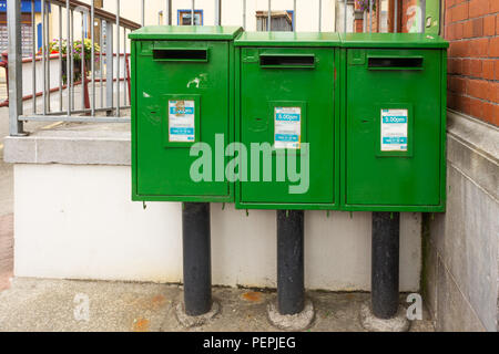 Irish green painted letter post box outside a traditional 19th century ...