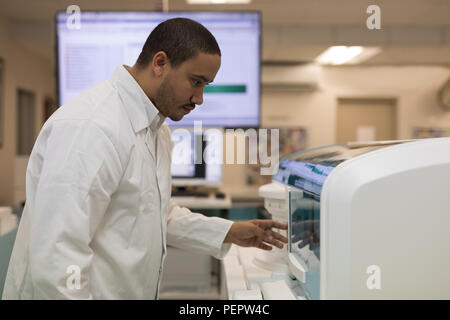 Laboratory technician using a machine Stock Photo - Alamy