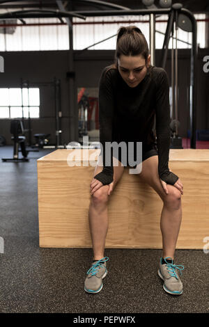 Exhausted beautiful millennial woman taking a break from exercise ...