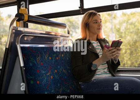 Female commuter using mobile phone while travelling in modern bus Stock ...