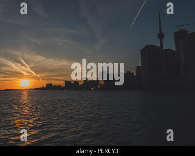 toronto skyline during sunset seen from toronto island with lake ...
