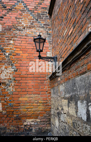 Modern streetlight on a corner of a house with an old white facade ...