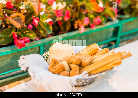Basket of breads and breadsticks on a table of restaurant Stock Photo ...