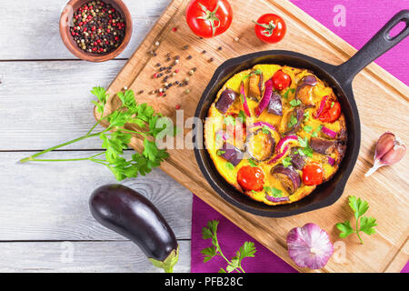 frittata with red onion, eggplant, tomato sprinkled with parsley on ...