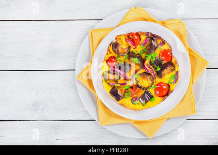 frittata with red onion, eggplant, tomato sprinkled with parsley on ...