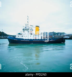 A side on view of a tug boat maneuvering down the cairns inlet in Far ...