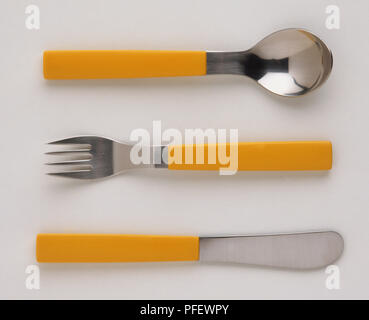 A knife and a fork with yellow plastic handles and a spoon with a blue ...