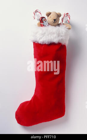 christmas sock with teddy bear and gifts hanging on a door Stock Photo ...