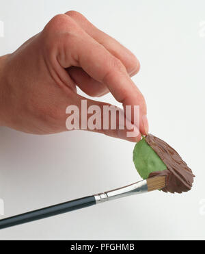 Human hand holding a brush and painting wood Stock Photo - Alamy
