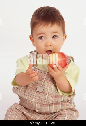 Child in a green plaid shirt cutting a banana with a safe kids plastic ...