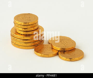 A stack of gold chocolate coins wrapped in a golden foil Stock Photo ...