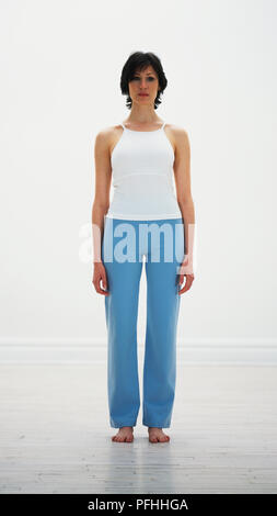 Woman standing upright, hands beside body, feet slightly apart, feet ...