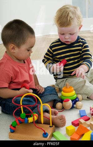Two baby boys playing with toys Stock Photo - Alamy