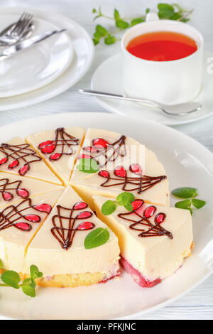 A top view of a berry cheesecake with a cup of tea surrounded by fresh ...