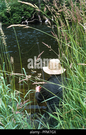 Rear view of man fishing in lake Stock Photo - Alamy